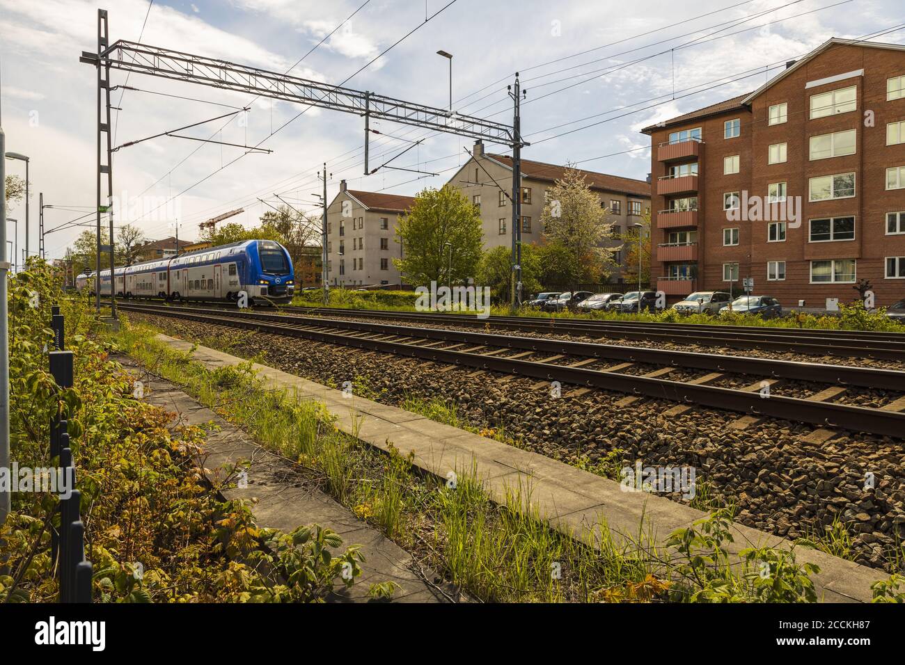 Beautiful city landscape view. Red speed train passing through city ...