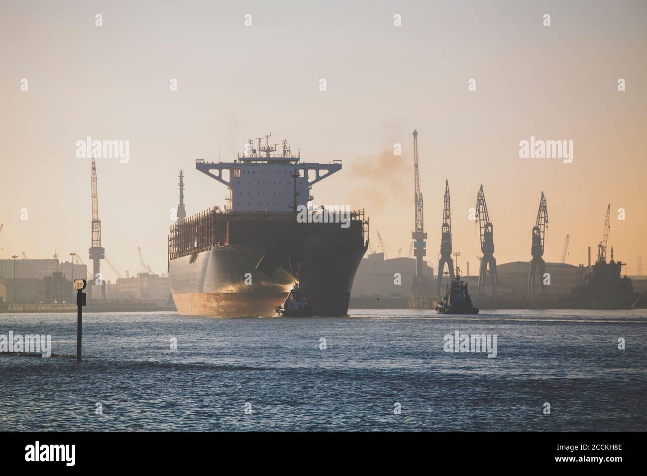 Germany, Hamburg, Ship leaving harbor at dusk Stock Photo - Alamy