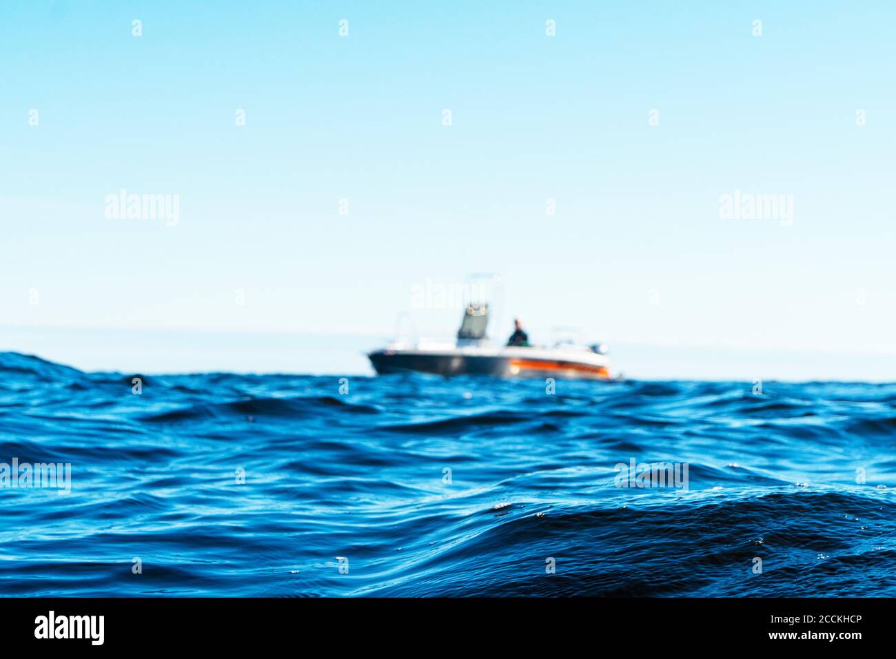 Water surface with blurred fisherman on boat in blue ocean. Beautiful ...