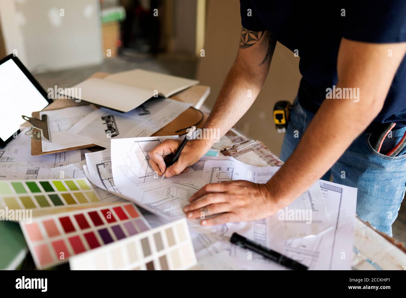 Man working on construction plan and colour swatch Stock Photo - Alamy