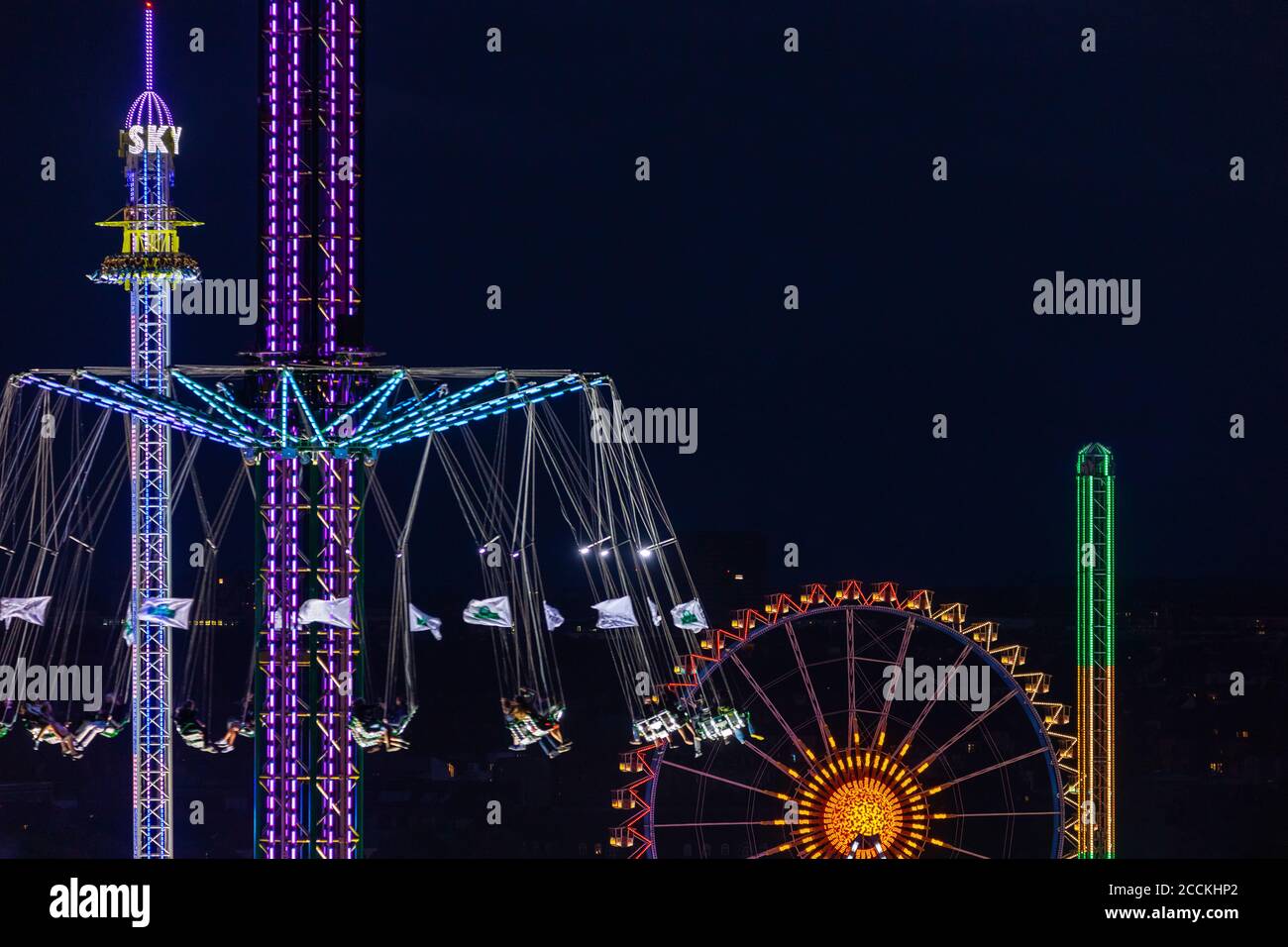 Germany, Bavaria, Munich, Aerial view of illuminated chain swing ride ...
