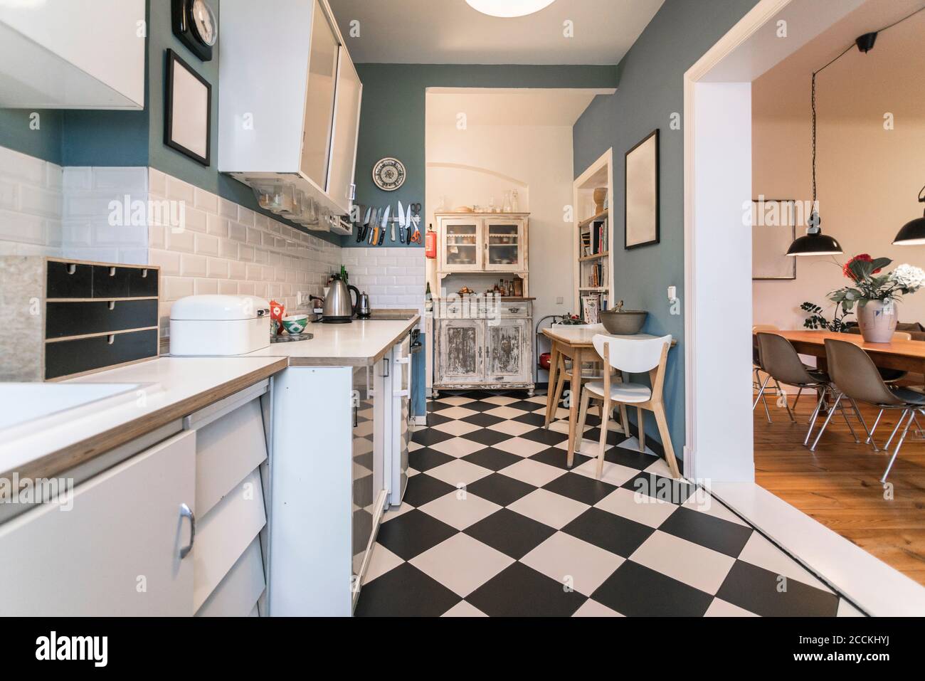 Tidy apartment kitchen with checkerboard floor Stock Photo - Alamy