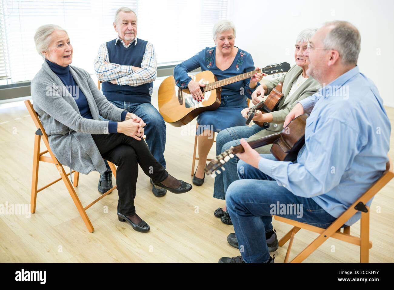 Seniors in retirement home attending guitar class, making music Stock ...