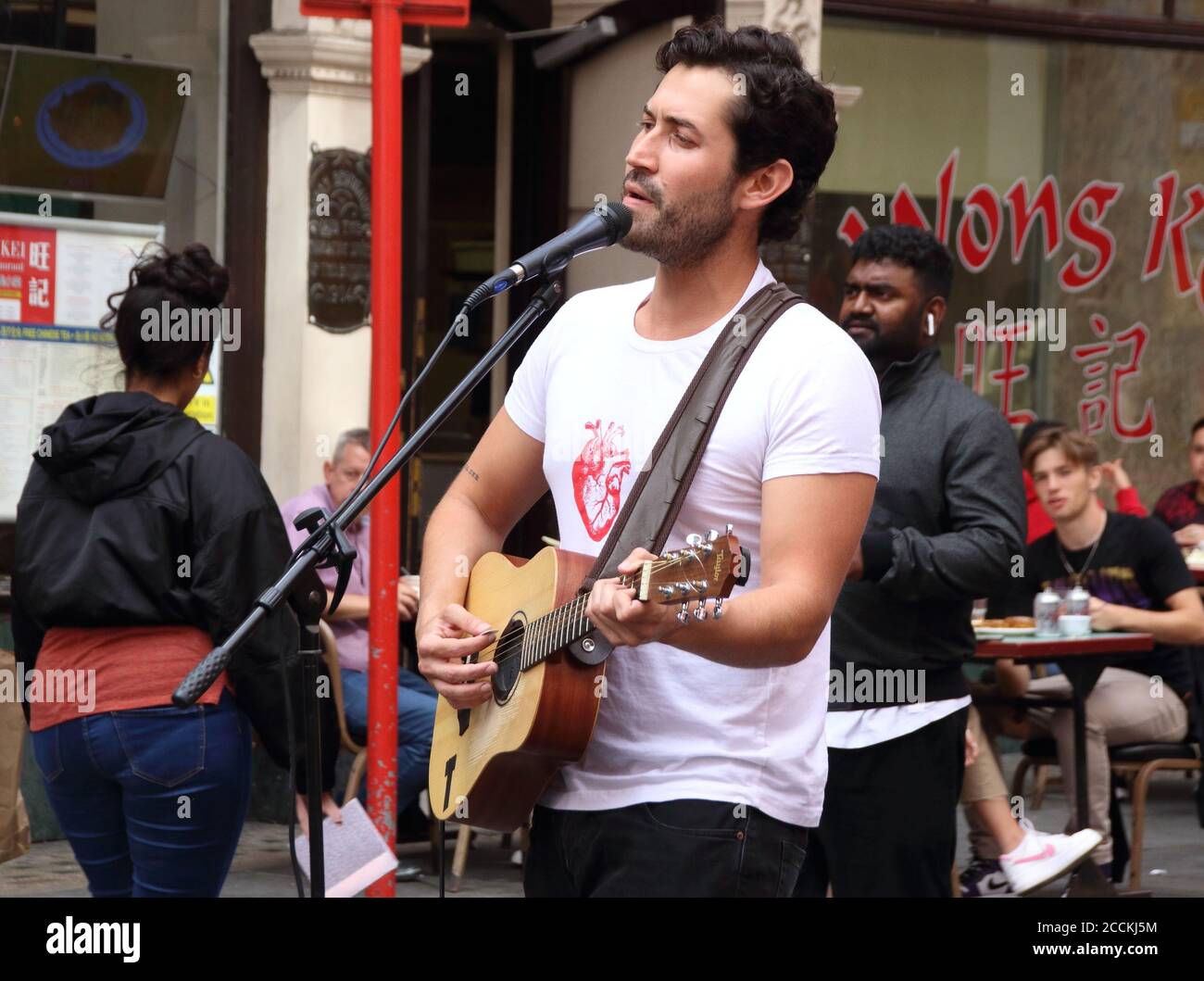 London, UK. 22nd Aug, 2020. Busker plays a guitar in Chinatown ...