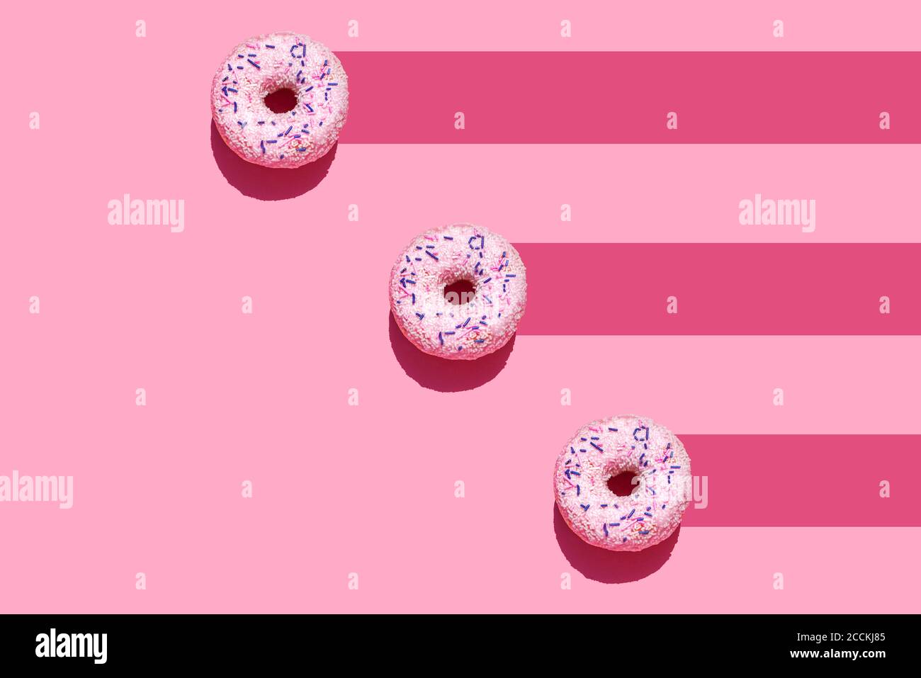 Studio shot of three sweet doughnuts with sugar sprinkles Stock Photo ...