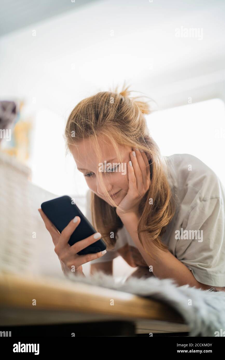 Girl using smartphone at home Stock Photo - Alamy