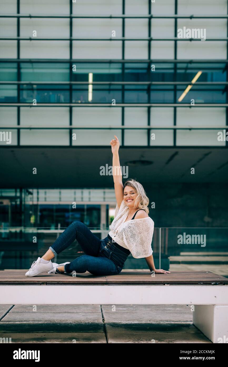 Smiling looking at camera sitting hand raised hi-res stock photography ...
