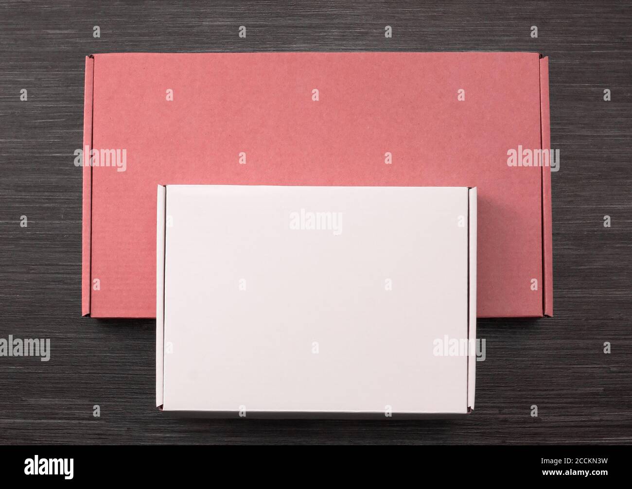 Living coral and white colors carton boxes on dark wooden desk. Copy ...