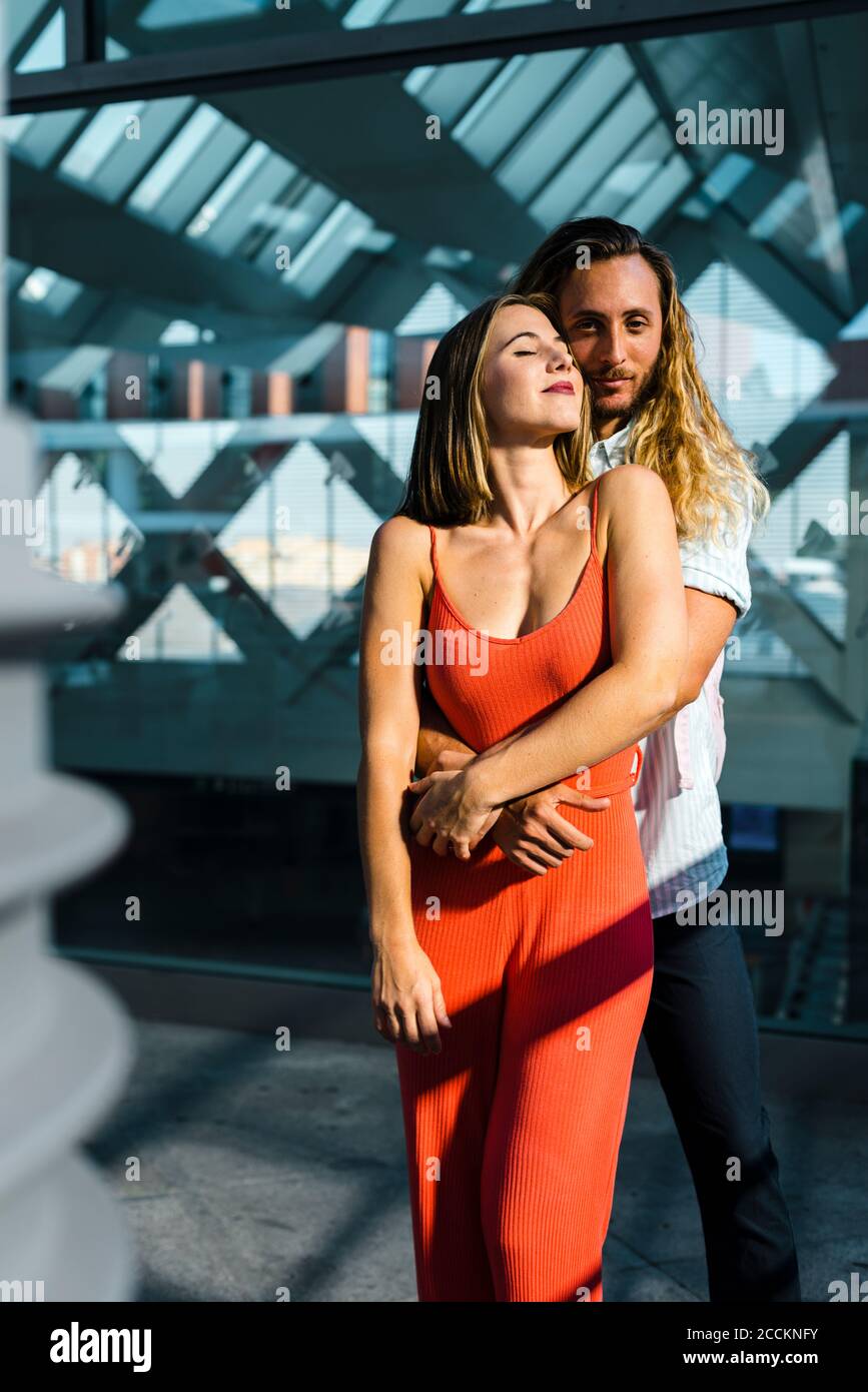 Boyfriend cuddling his girlfriend from behind at railroad station Stock ...