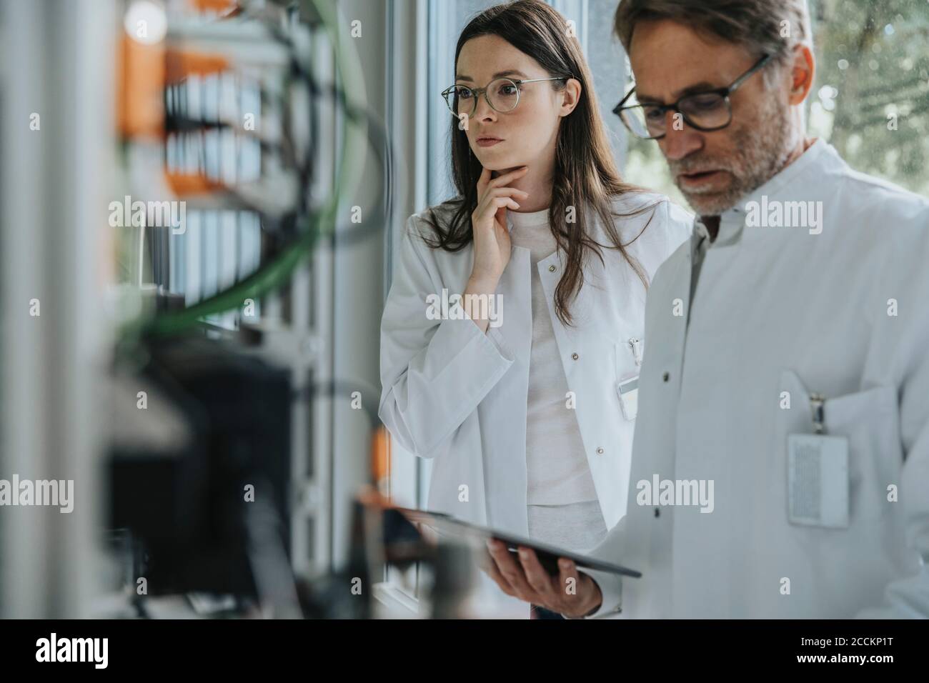 Serious scientist examining machinery in laboratory Stock Photo - Alamy