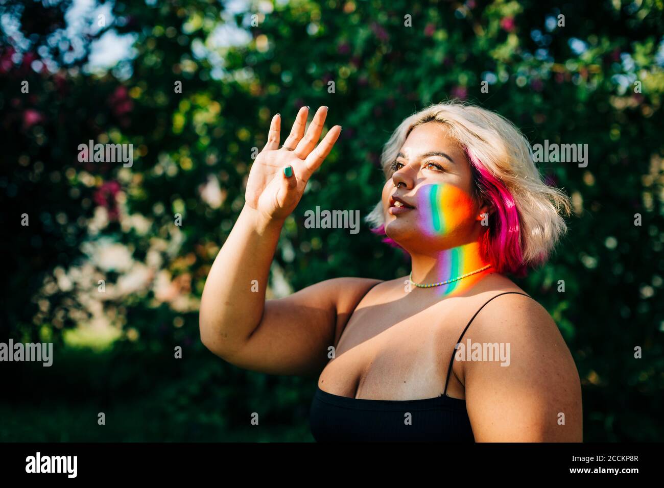 Beautiful woman blocking light reflection with hand in park Stock Photo ...