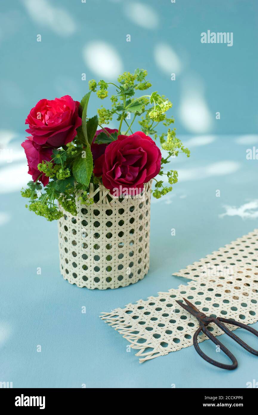 Red roses in Vase made of a jam jar and Viennese braid and scissors ...