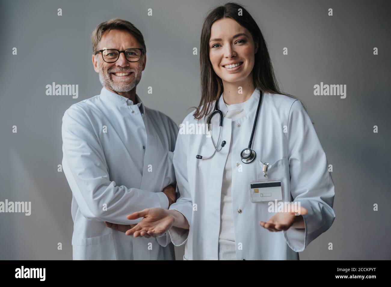 Smiling doctors standing against wall in hospital Stock Photo - Alamy