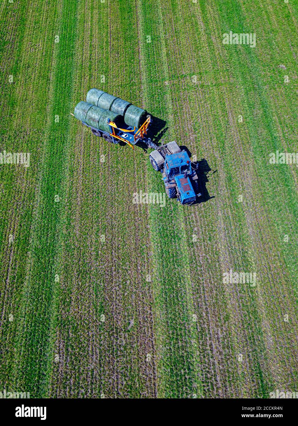 Aerial view of tractor collecting hay bales in field Stock Photo - Alamy