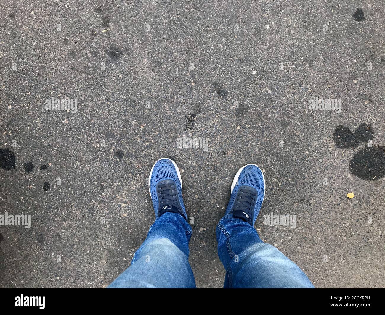 Person leg foot shoe on pavement road asphalt street. Outdoor road with ...