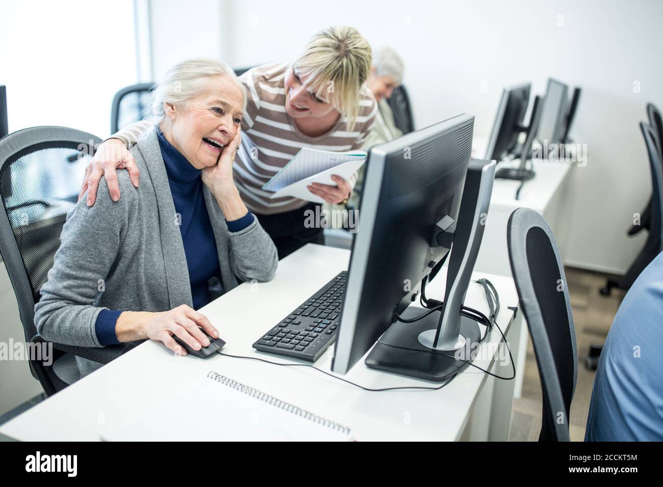 Active seniors attending computer course, intructor giving advice Stock ...