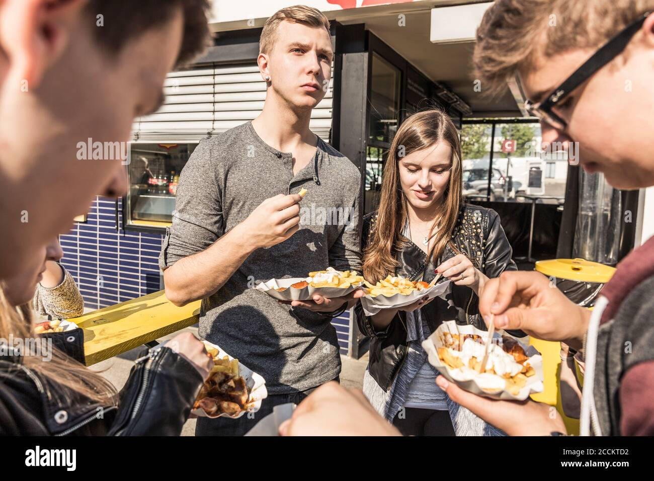 Group of friends hanging out in the city having a snack Stock Photo - Alamy