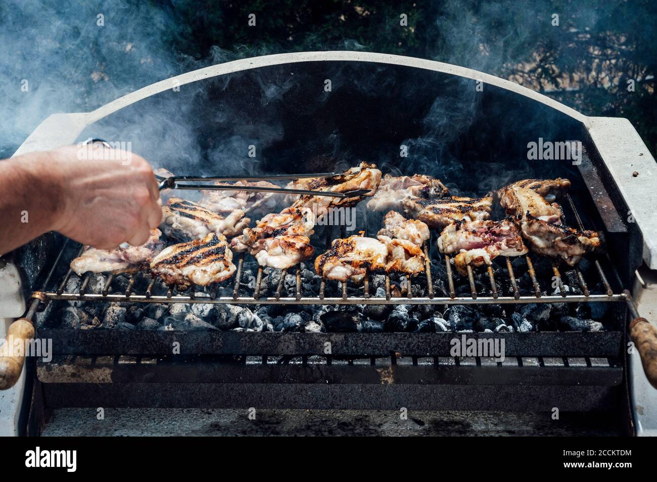 Hand holding cooking tongs hi-res stock photography and images - Alamy