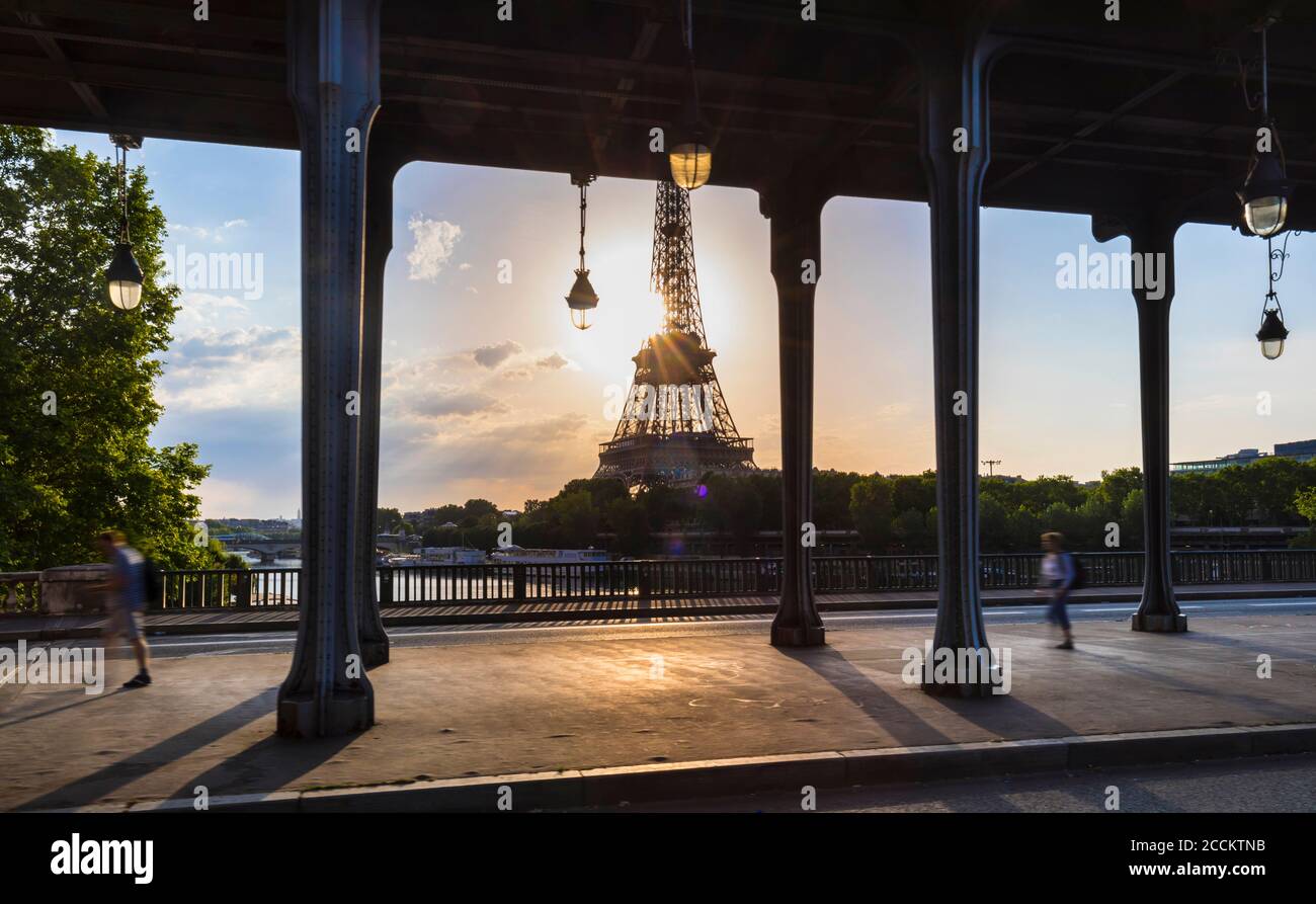 Eiffel Tower seen from bridge against blue sky during sunrise, Paris ...