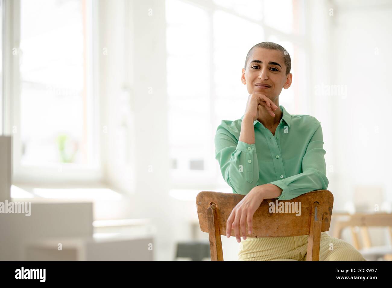 Portrait of a confident woman sitting on chair in a loft Stock Photo ...