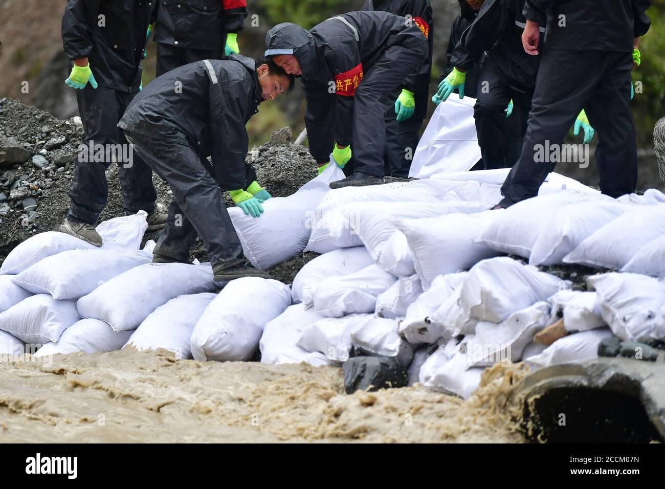 Gansu, China. 23rd Aug, 2020. Rescuers repair a road destroyed by flood ...