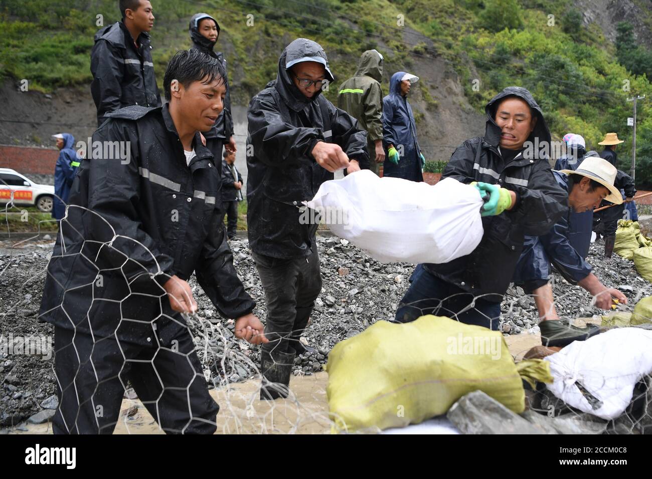 Gansu, China. 23rd Aug, 2020. Local villagers repair a road destroyed ...