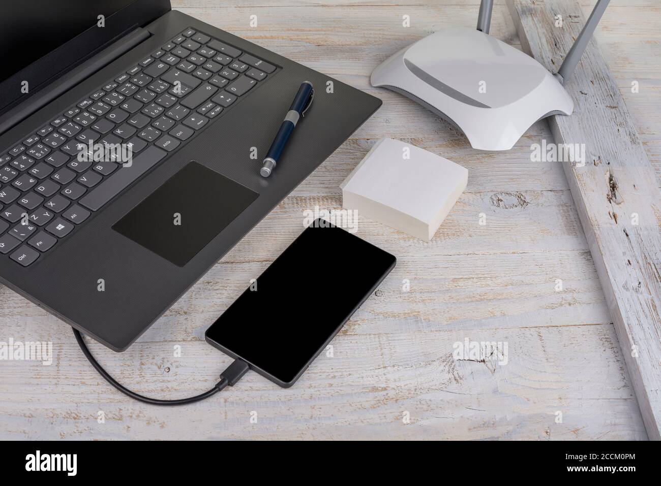 Modern laptop smartphone wih a usb cable on a wood Stock Photo - Alamy