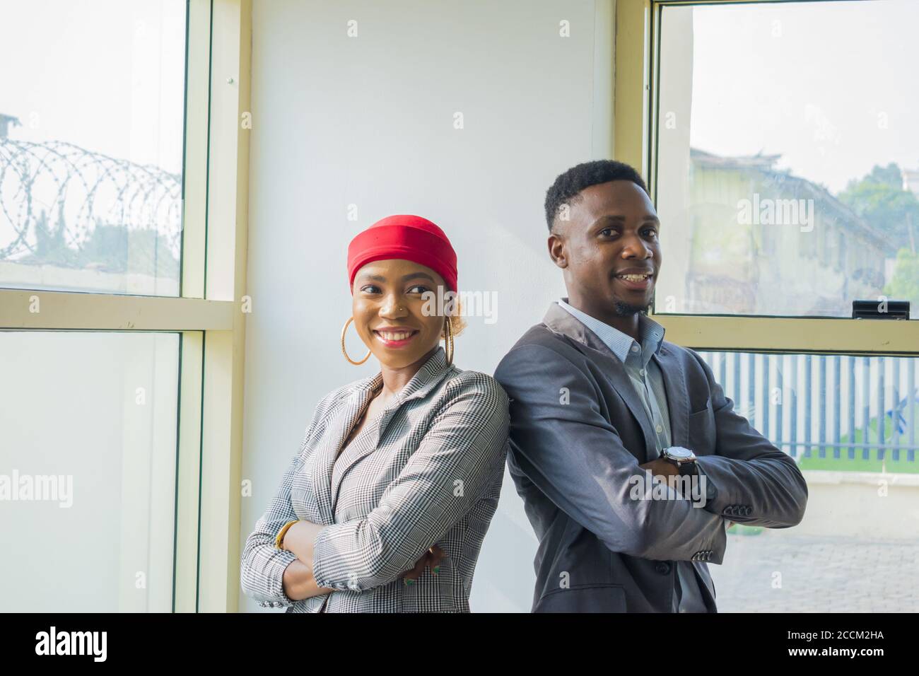 Business partners standing back to back with folded arms- the concept ...