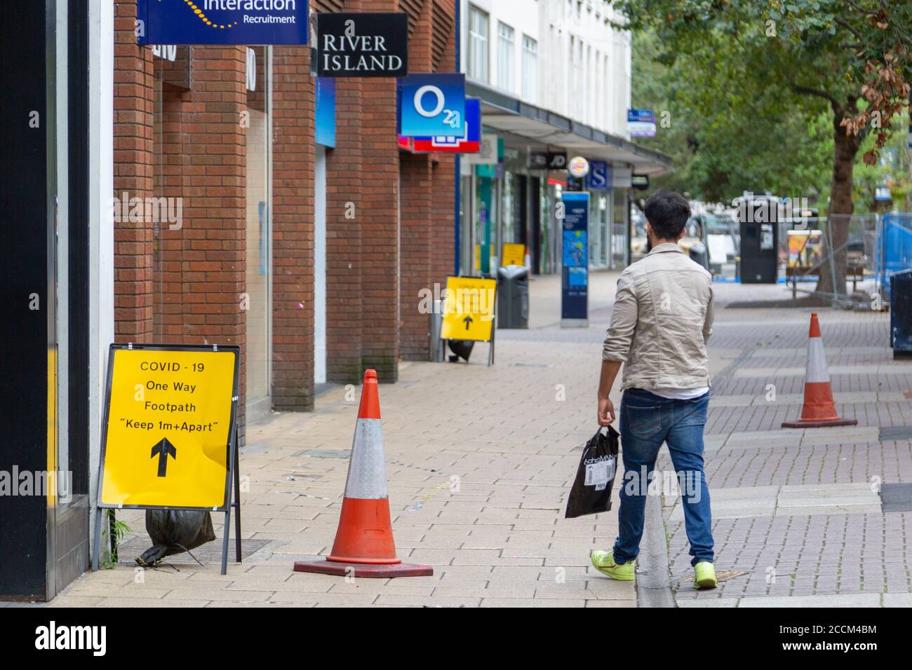 A sign in the high street asking people to follow a one way system and ...