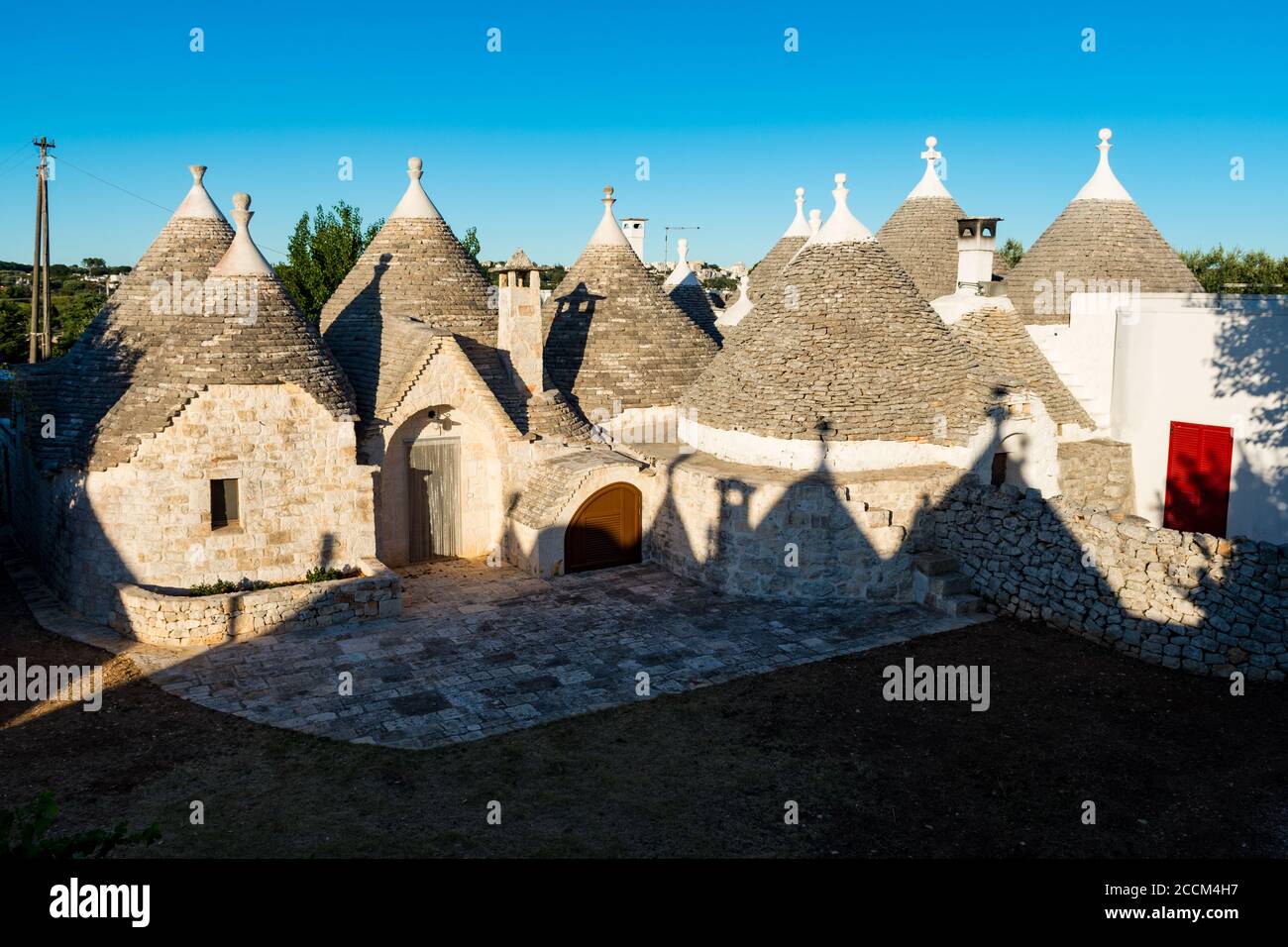 Group of Trulli, traditional old houses and old stone wall in Puglia ...