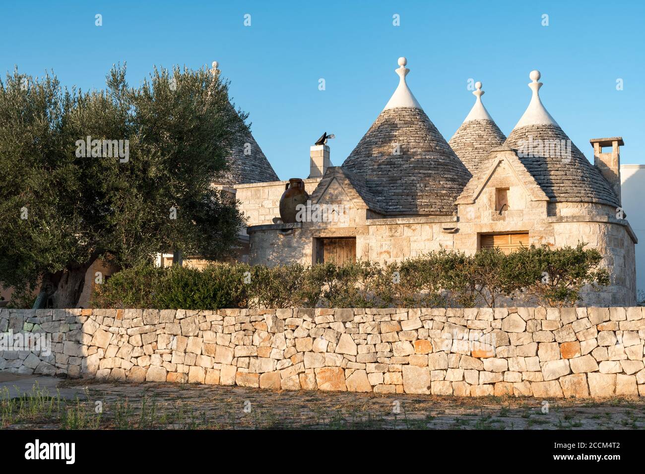 Group of Trulli, traditional old houses and old stone wall in Puglia ...