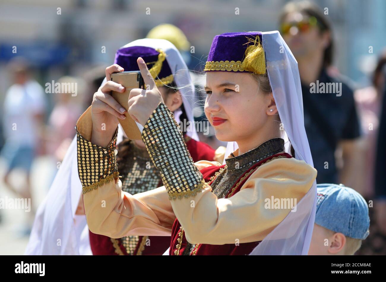Girl in traditional Crimean Tartar dress and fez taking picture by ...