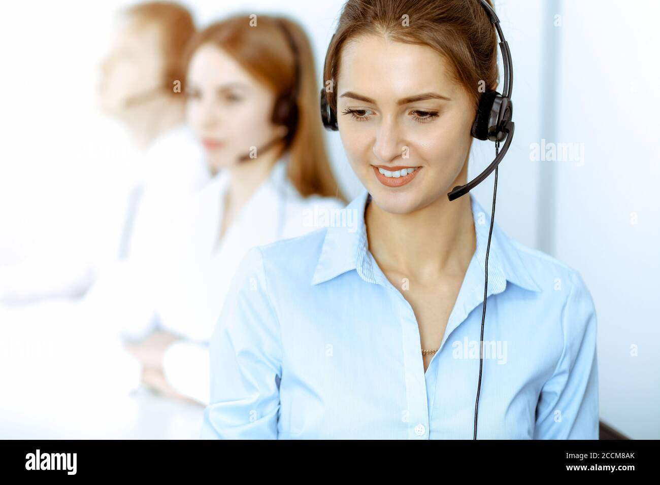 Call center. Focus on beautiful business woman in headset Stock Photo ...