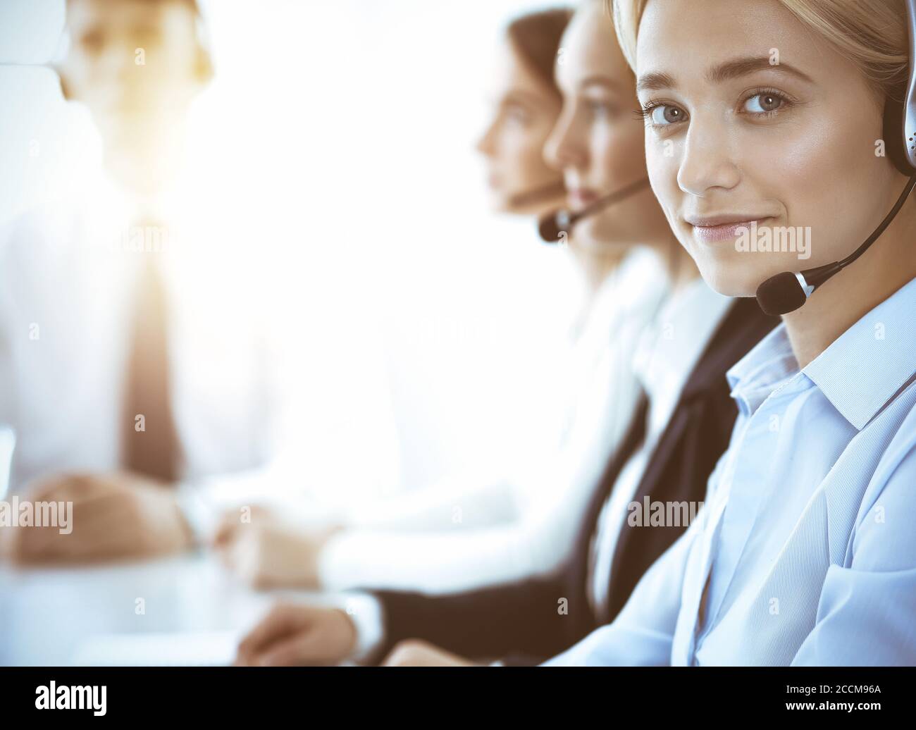 Call center and business people concept. Beautiful business woman with headphones consulting ...