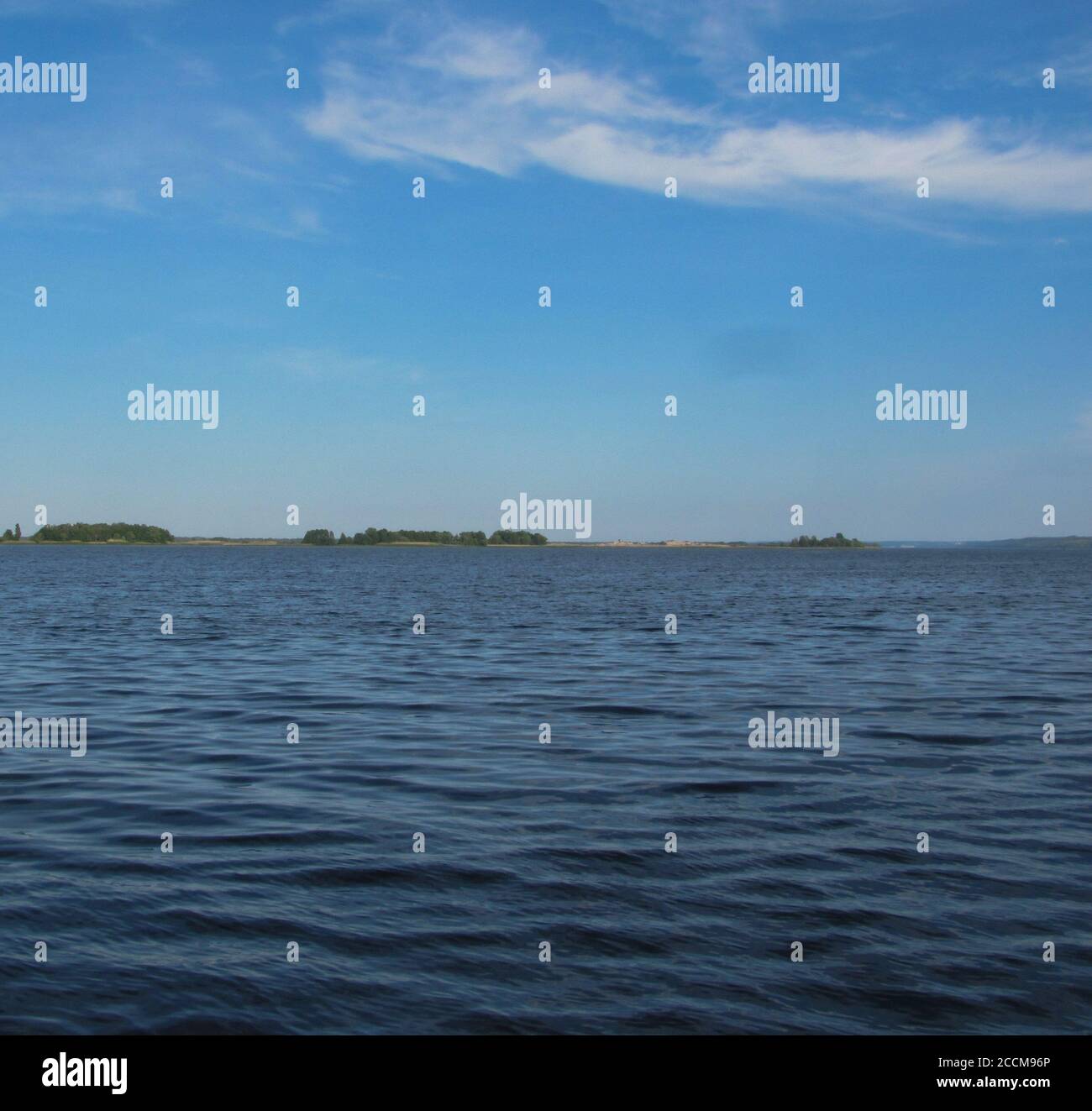 large water area with ripples and forest on the horizon Stock Photo - Alamy