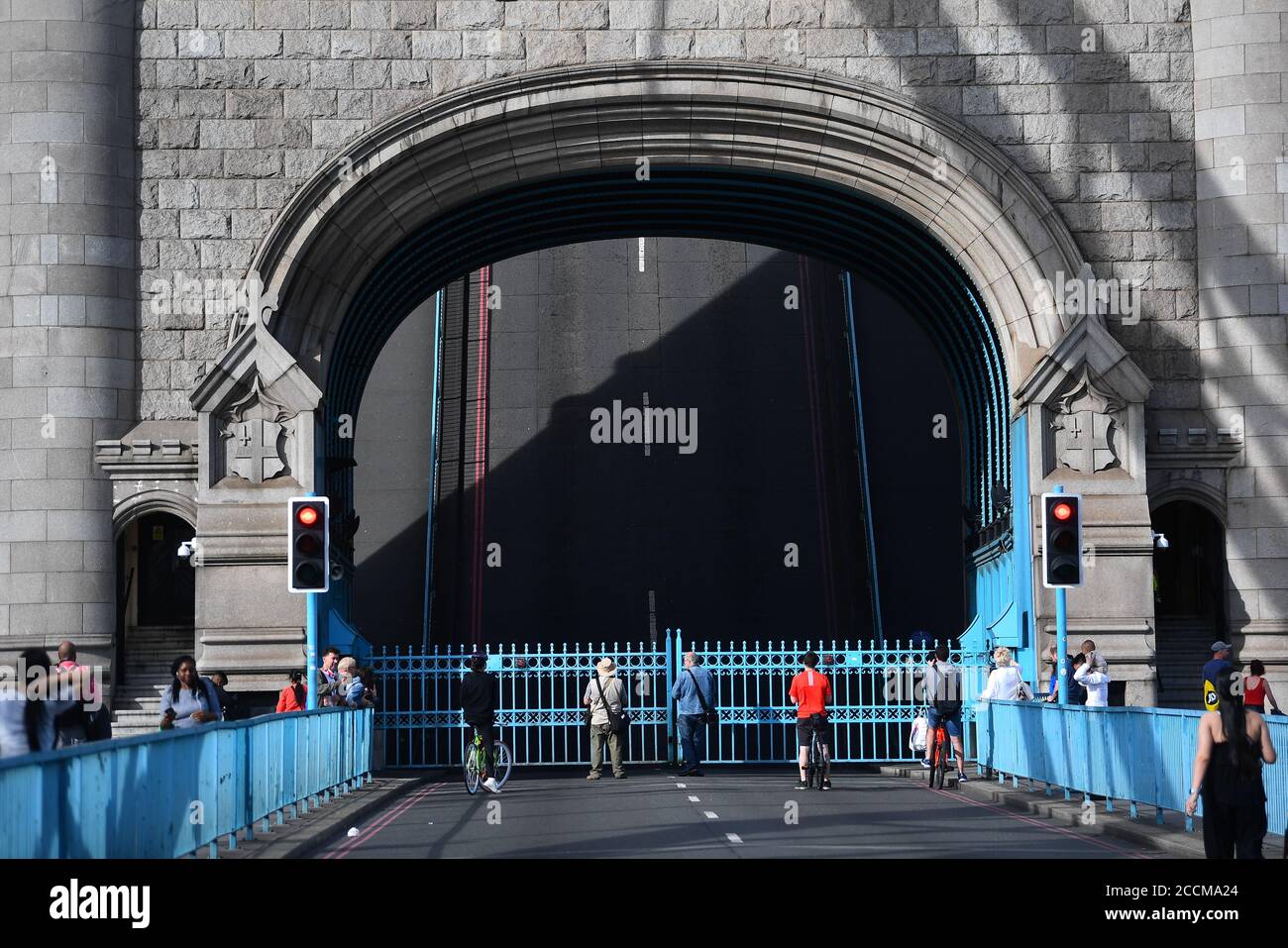 Pedestrians wait to cross Tower Bridge, London, after it was raised to ...
