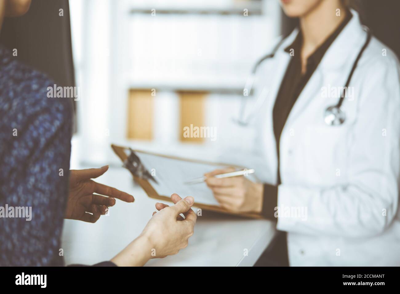 Doctor and patient discussing current health examination while sitting ...