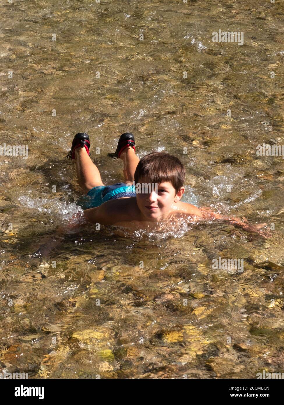 Happy boy having fun swimming in the river water Stock Photo - Alamy