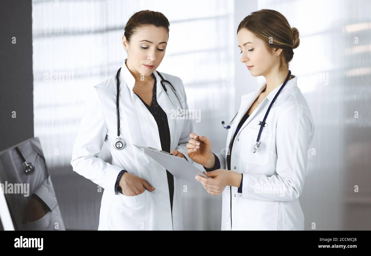 Two female physicians are discussing their patient's medical tests ...