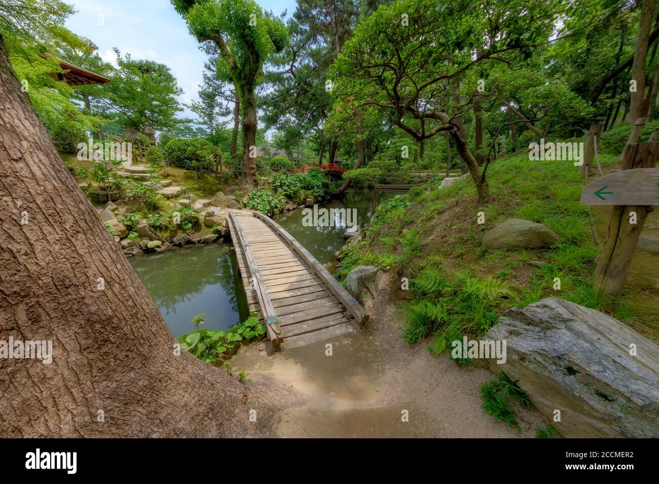 Beautiful garden with a path bridge over stream Stock Photo - Alamy