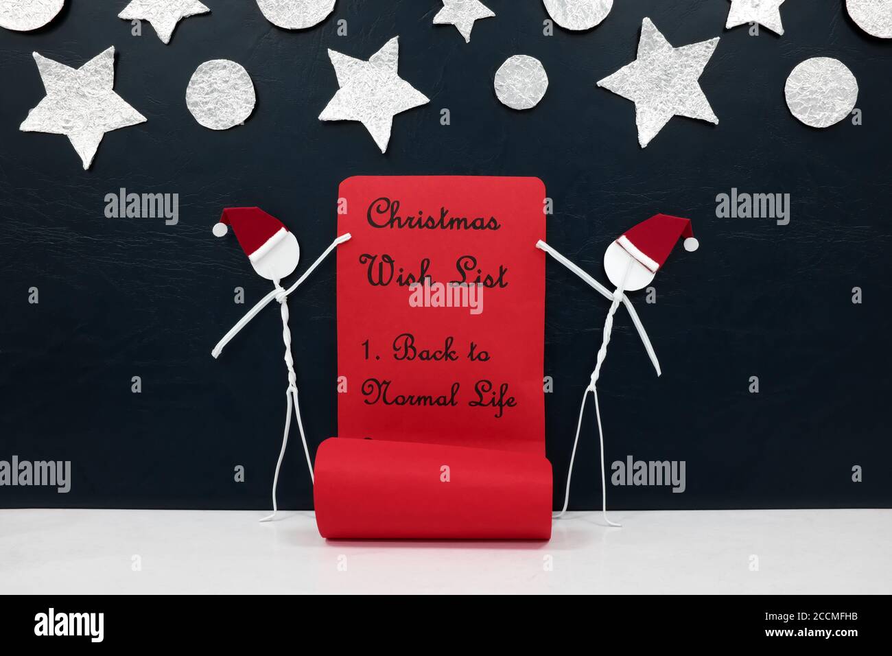 Stick man figure holding a red paper roll with christmas wish list ...