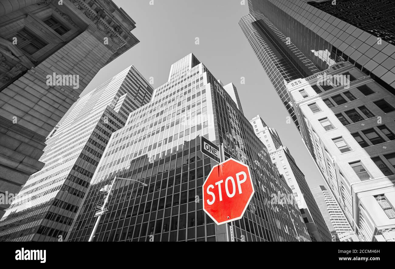 Red stop sign with black and white buildings in background, selective ...