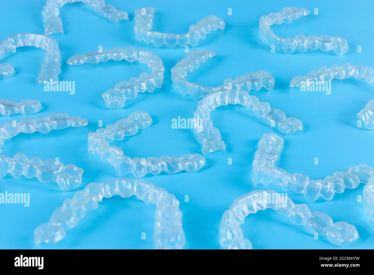 Many invisalign transparent brackets on blue background Stock Photo - Alamy