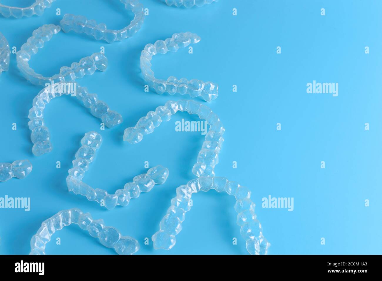 Invisalign transparent brackets on blue background Stock Photo - Alamy