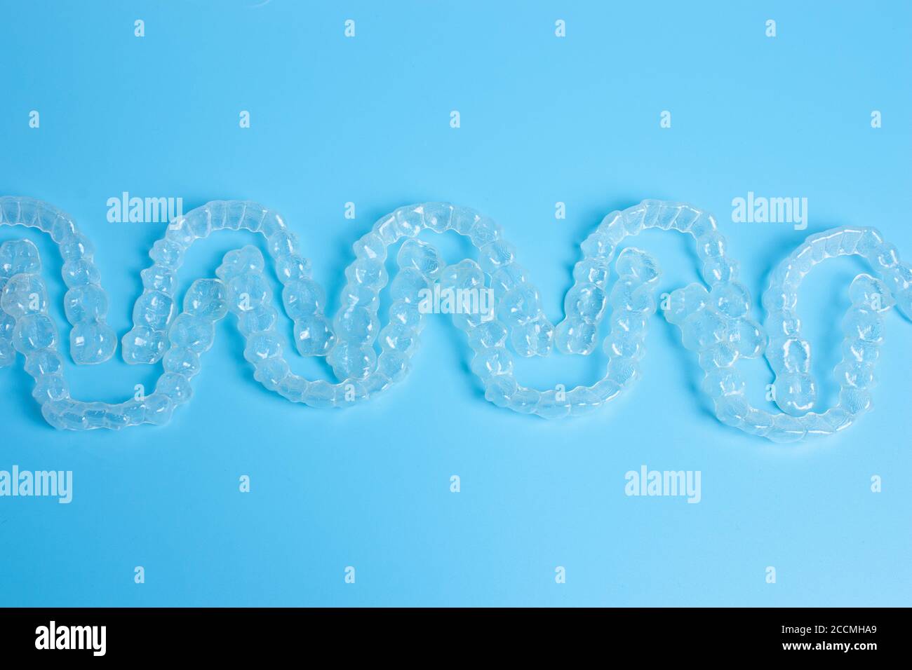 Invisalign transparent brackets on blue background Stock Photo - Alamy