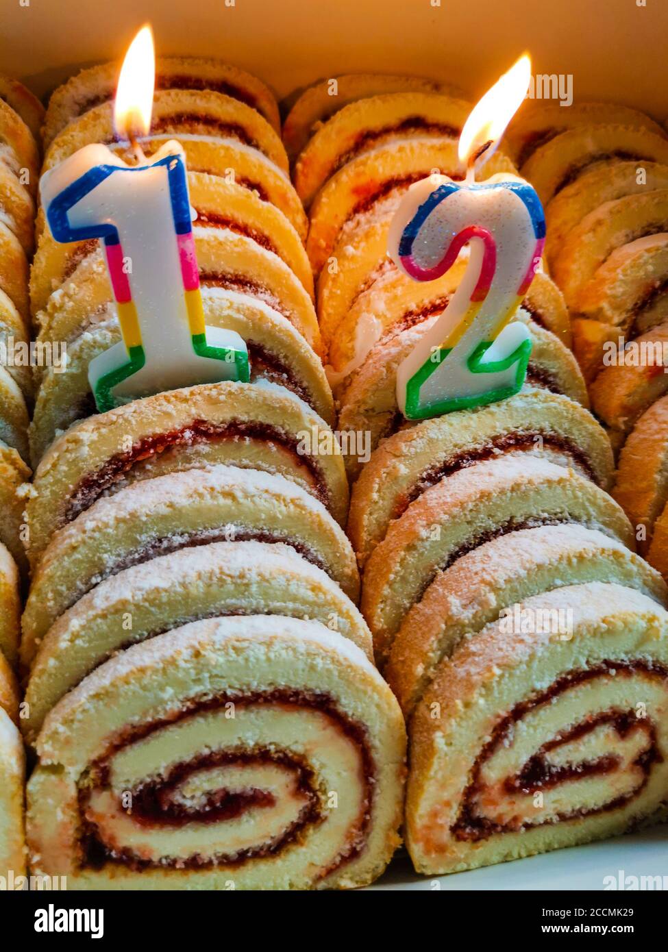 Delicious homemade swiss roll slices with jam and number candles served ...