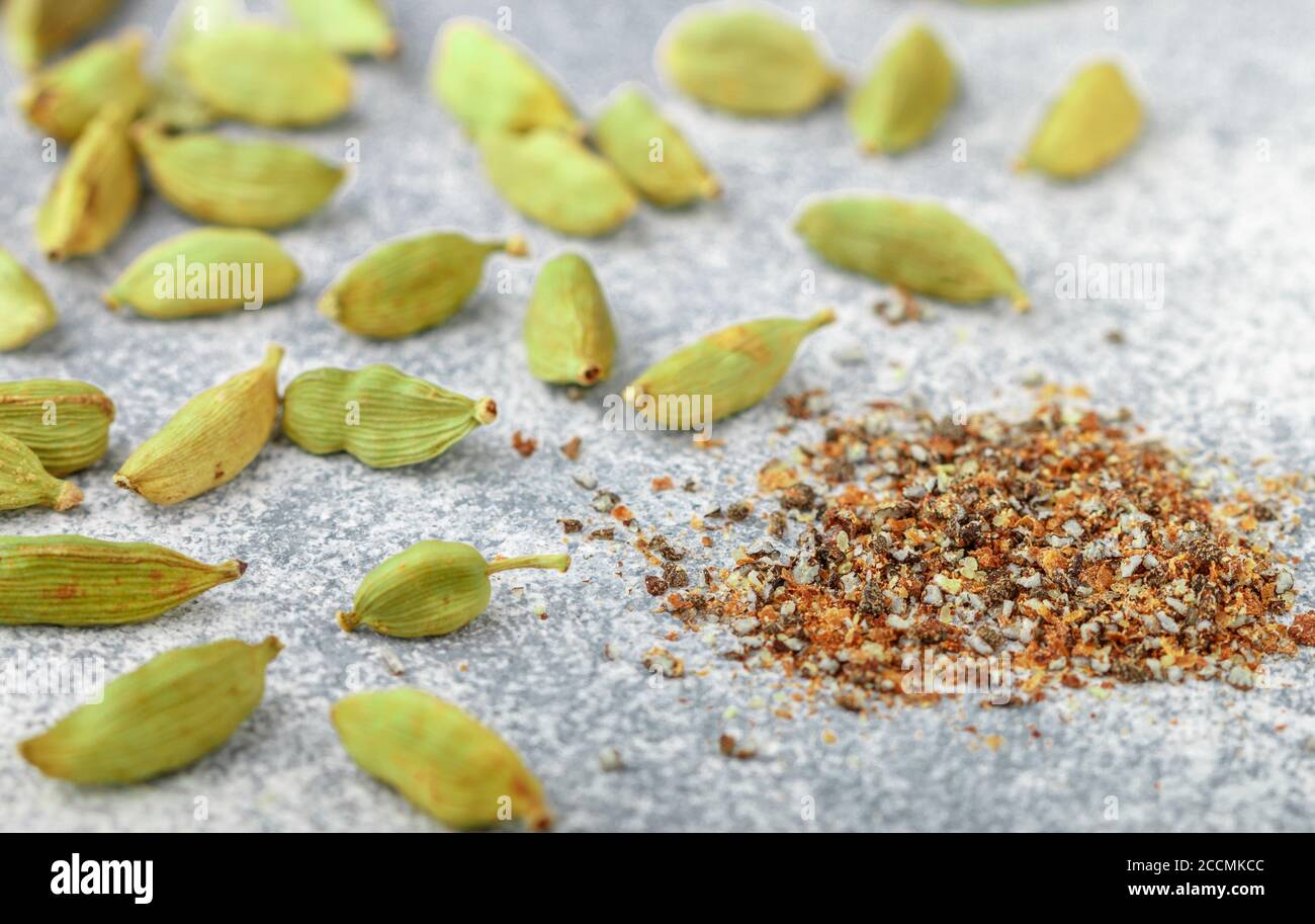 Ground cardamom seeds and whole pods close-up. Seasonings and spices ...