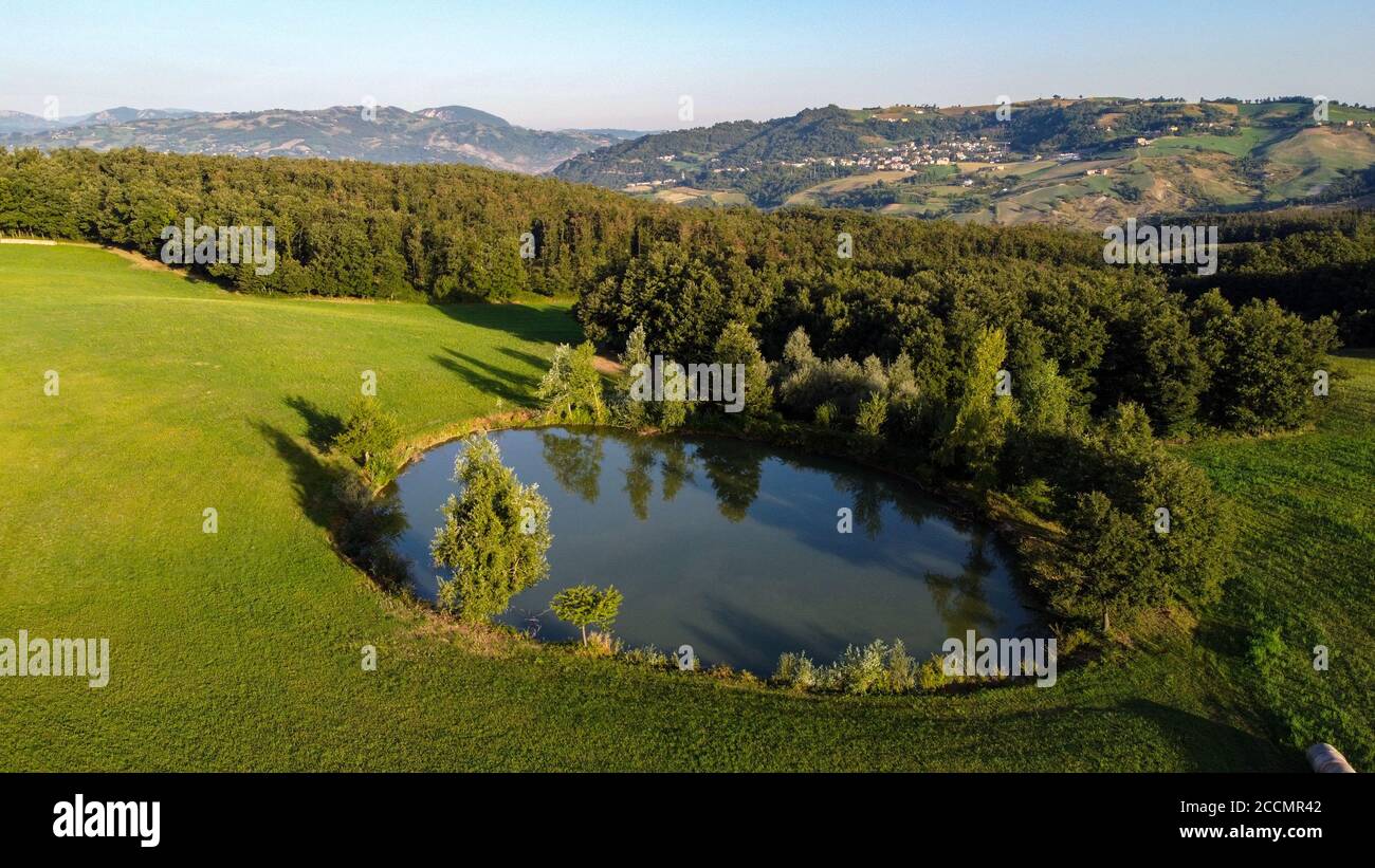 Aerial view of a little lake and trees surrounding, in italian ...