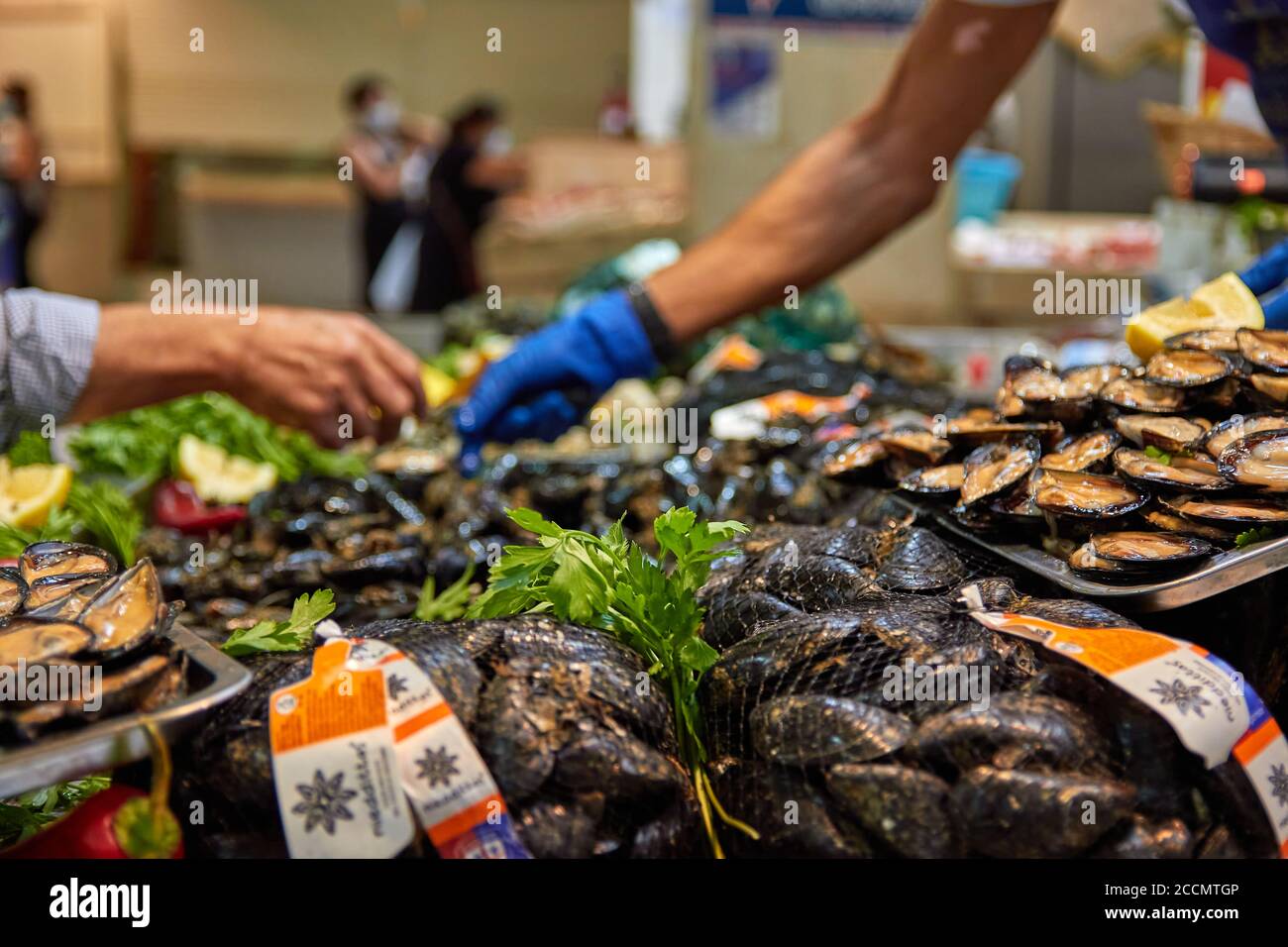 Fishmonger selling raw mussels seafood at sardinian fish market Stock ...