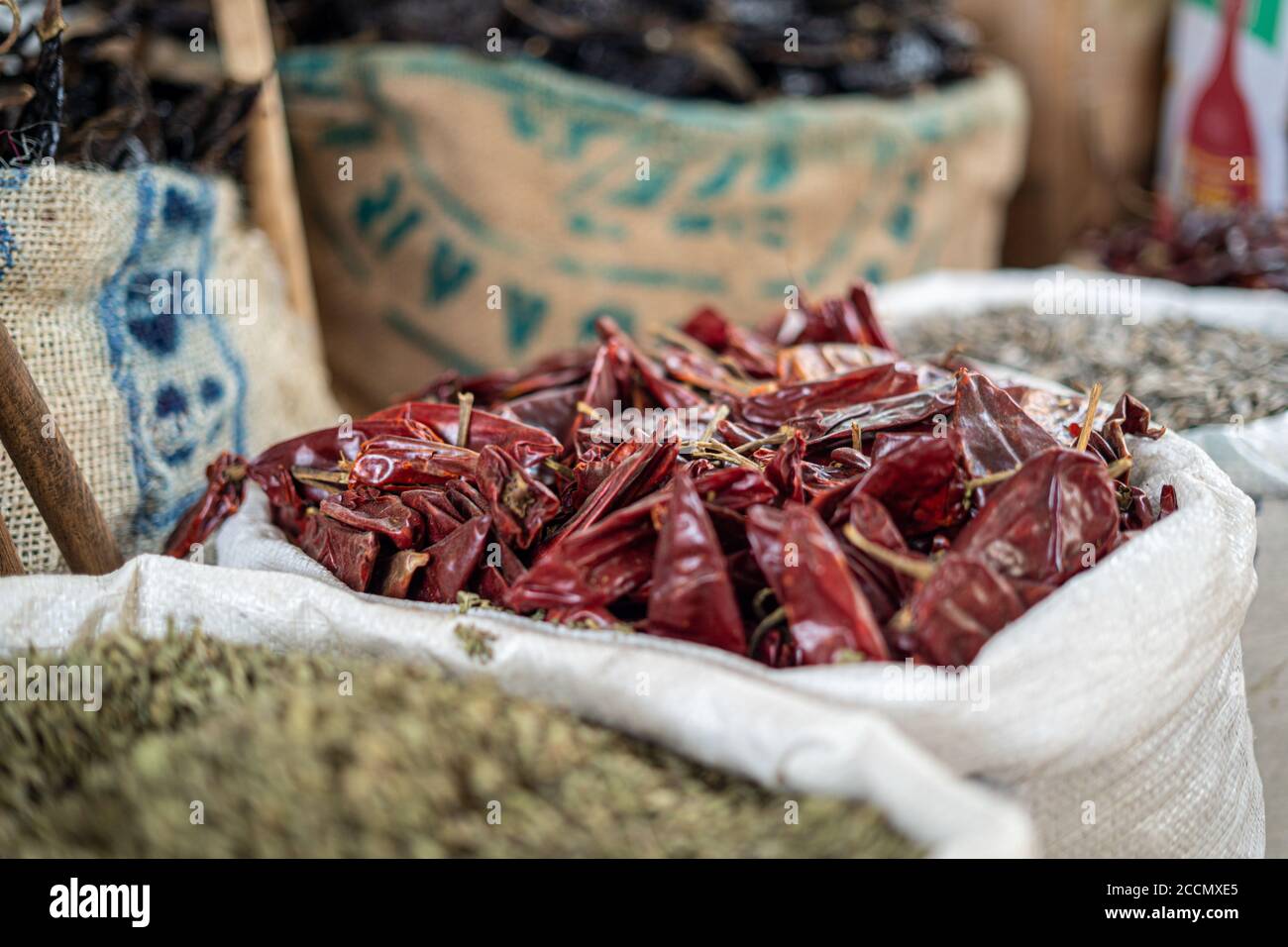 Closeup of a gunny sack filled with dry chili peppers in a marketf ...